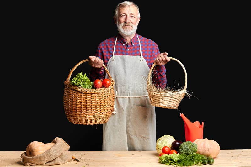 Gray-haired Farm Worker Standing Holding Baskets with Fresh Vegetables ...