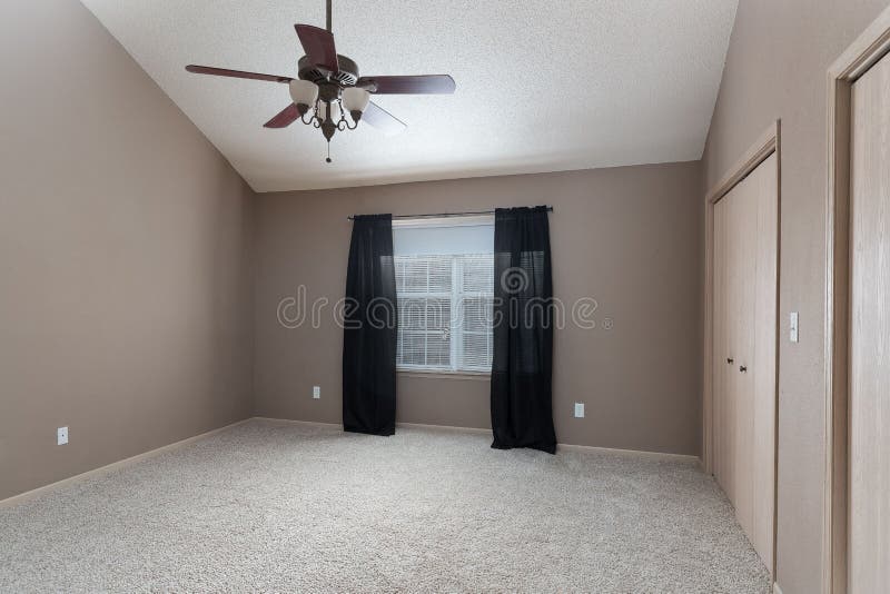 View of a Half-empty Room with Curtains, Shelf Doors, and Carpeted ...