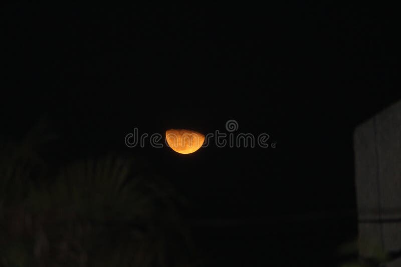 View of the Half Orange Moon Partially Hidden by Clouds Stock Image ...