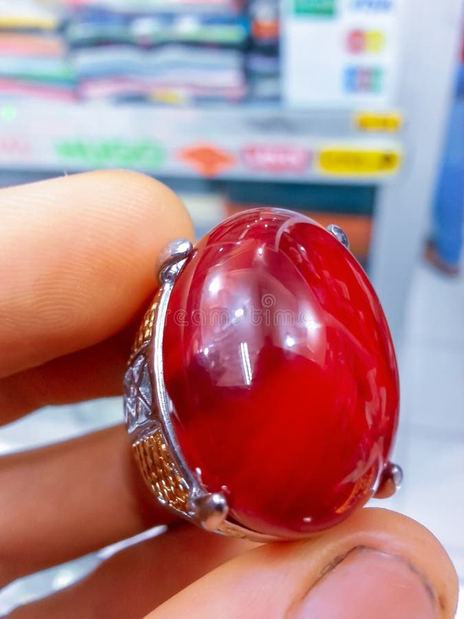 View of Hand Holding a Ring with a Ruby Stone Attached on it , Taken ...