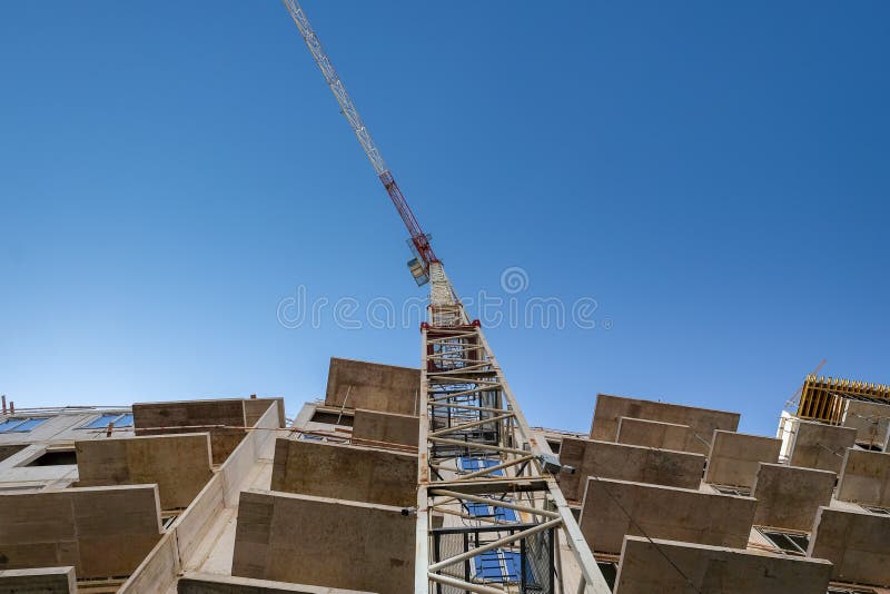 View of High Rise Building Construction with Crane Against Blue Sky ...