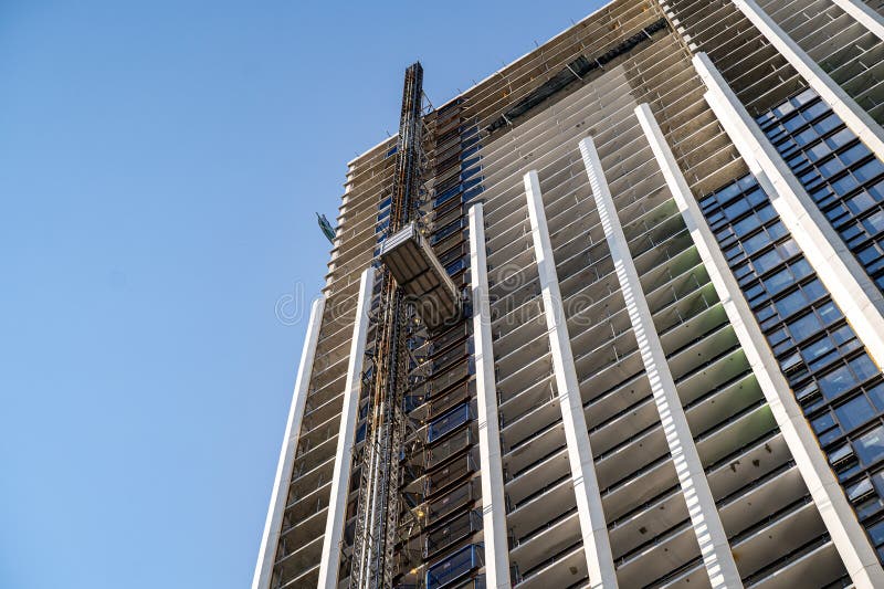 View of High Rise Building Under Construction with External Elevator ...