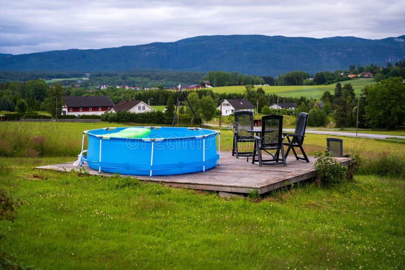 View of an Inflatable Pool Full of Water and a Table Set in the Green ...