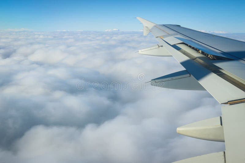 View from Inside of Airplane Window Looking at Airplane Wing and Clouds ...