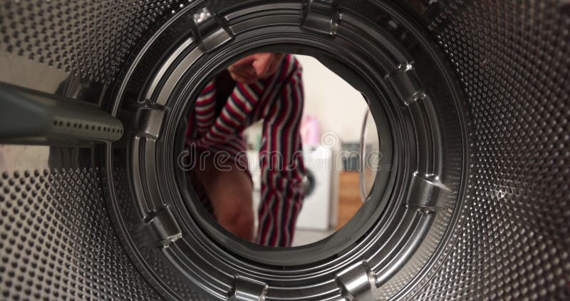 View from Inside a Washing Machine, a Man Puts a Colored Wash into the ...
