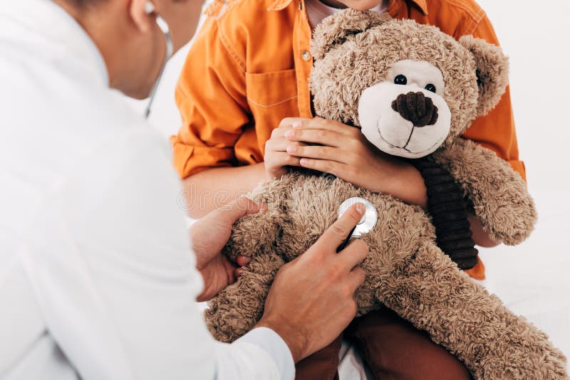 View of Kid and Pediatrist in White Coat Examining Teddy Bear with ... View of Kid and Pediatrist in White Coat Examining Teddy Bear with ...
