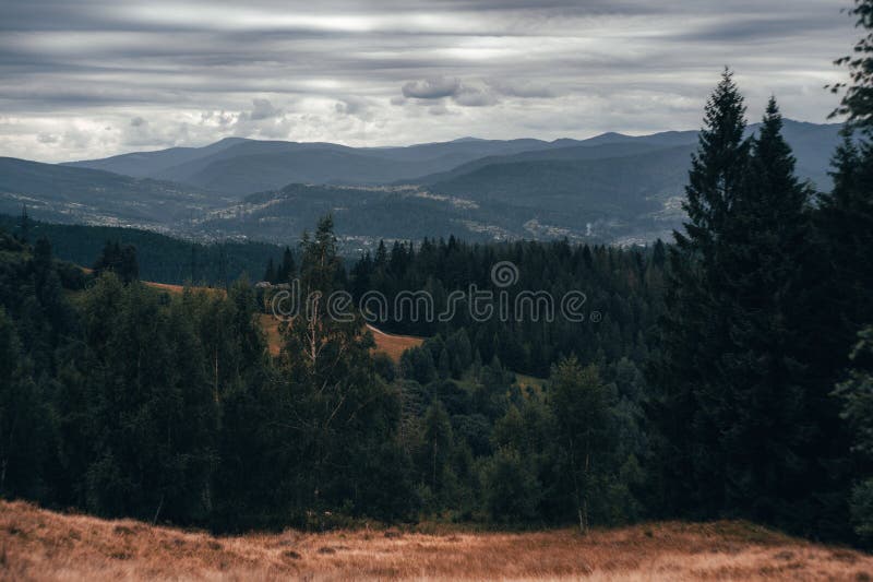 A View of Layered Mountain Ridges Stretches into the Distance, with a Dark, Cloudy Sky Overhead ...