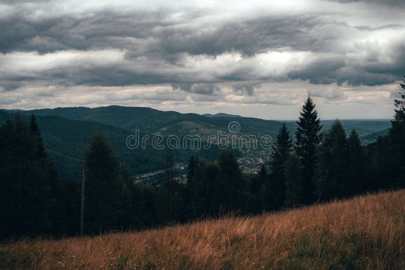 A View of Layered Mountain Ridges Stretches into the Distance, with a Dark, Cloudy Sky Overhead ...