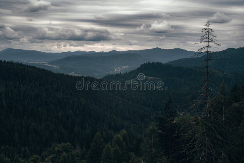 A View of Layered Mountain Ridges Stretches into the Distance, with a Dark, Cloudy Sky Overhead ...
