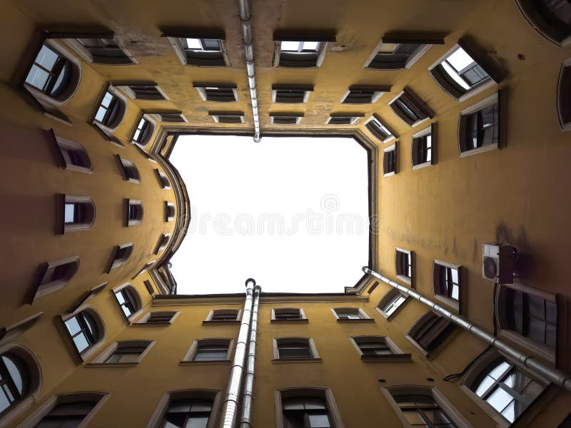 Looking Up at Yellow Building Courtyard with Windows and Pipes Stock ...