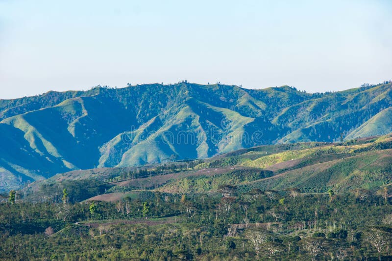 View of Mountain Ridges and Sloping Hills with Trees Under a Clear Blue ...