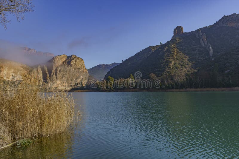 A View of the Mountains and Rocks Rising Above the Surface of a Calm ...