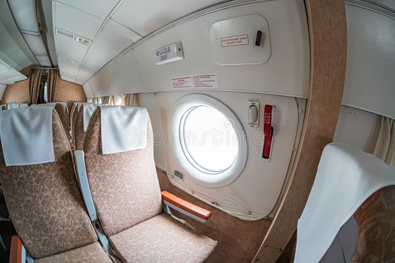 View of an Older Model Airplane Cabin with Light-colored Upholstered ...