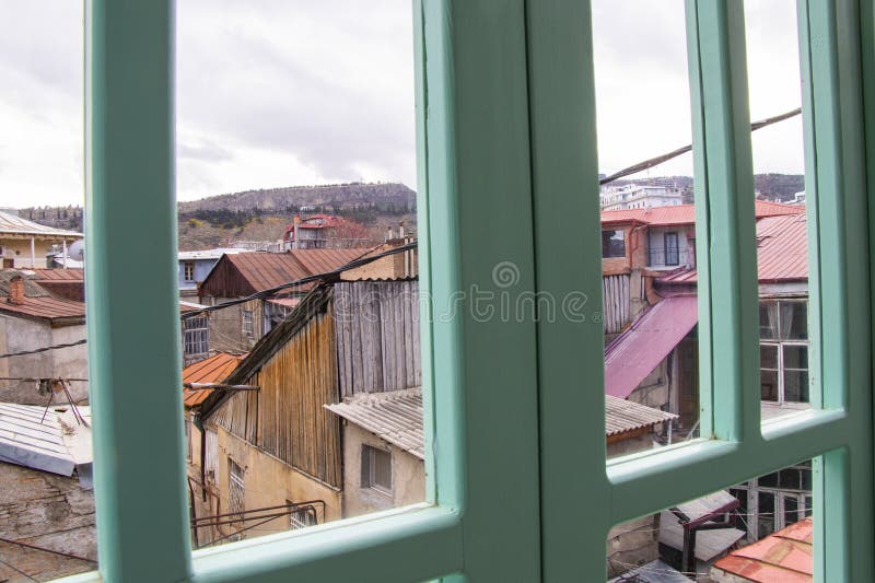 The View Outside of an Open Window Shows Several Buildings in the ...