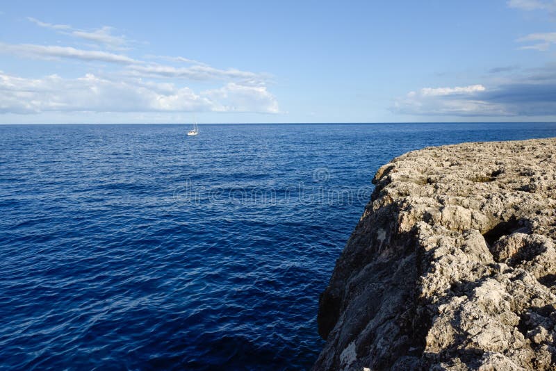 View Over the Ocean from a Cliff As a Boat Sails in the Distance Stock ...