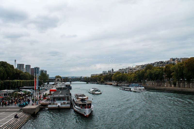 View Over the River Seine with Boats and People Walking on the Sidewalk ...