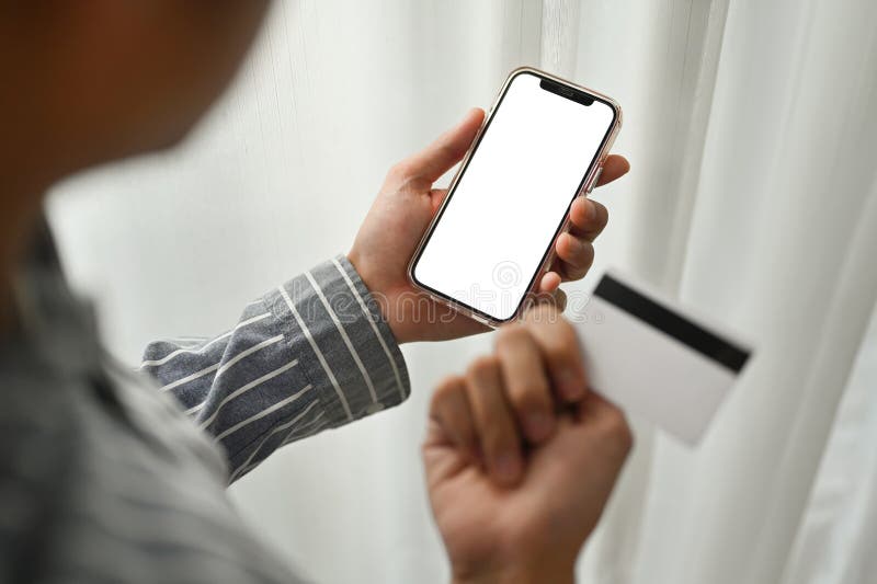 View Over Shoulder of Man Holding Credit Cad and Using Mobile Phone for ...