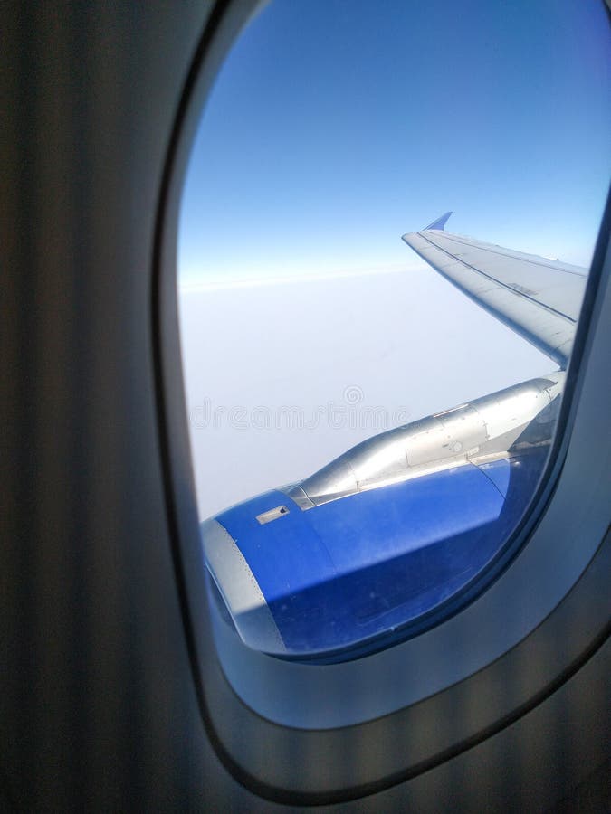 A View from a Plane Window during Flight in Blue Sky Stock Photo ...