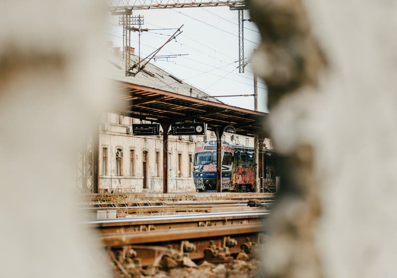 View of a Railway Station with a Train Seen through a Hole in the Wall ...
