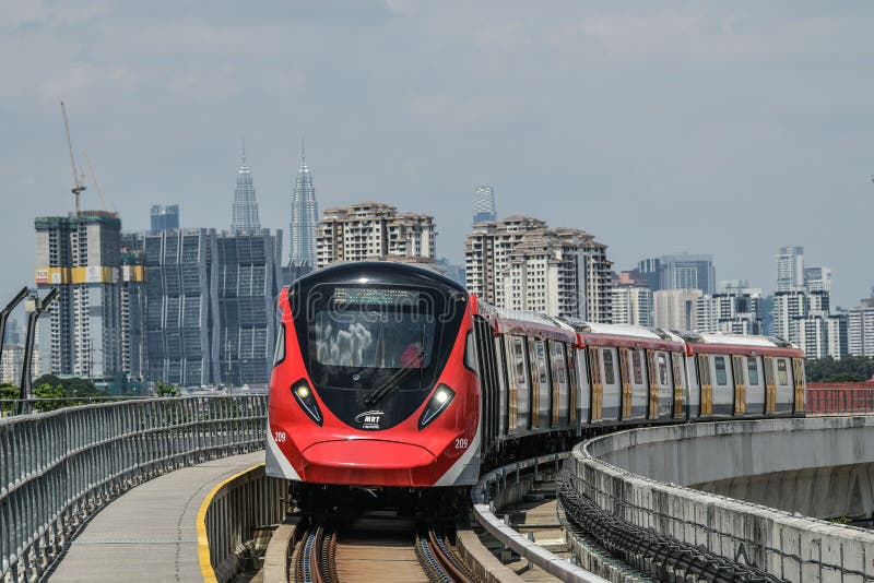 View of a Red Mass Rapid Transit on the Railroad before the Cityscape ...