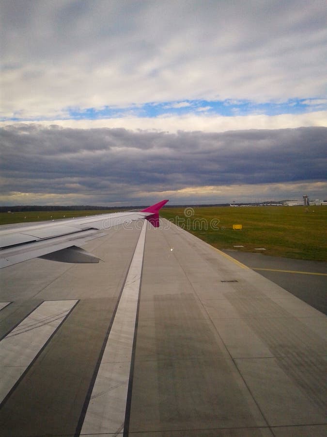 View of the Runway and the Wing of the Plane through the Porthole Stock ...