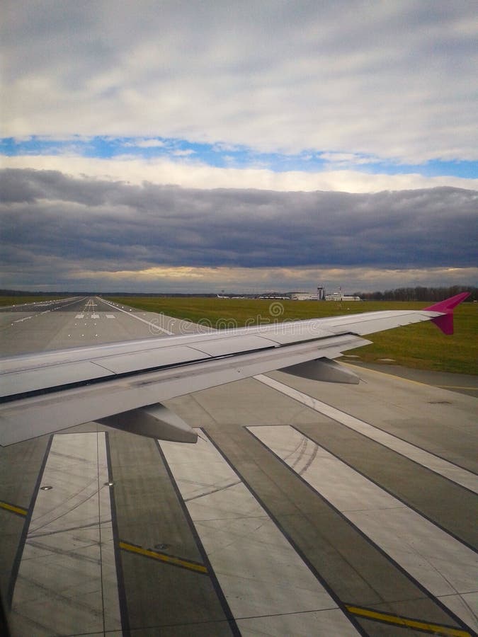 View of the Runway and the Wing of the Plane through the Porthole Stock ...