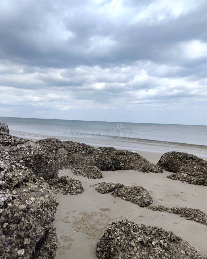 A View of the Sea with Large Rocks Lining the Beach Stock Image - Image ...