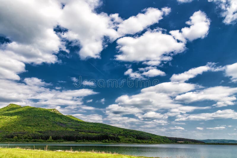 View from the Shore To the Lake, Hills, and Beautiful Clouds in the Sky ...