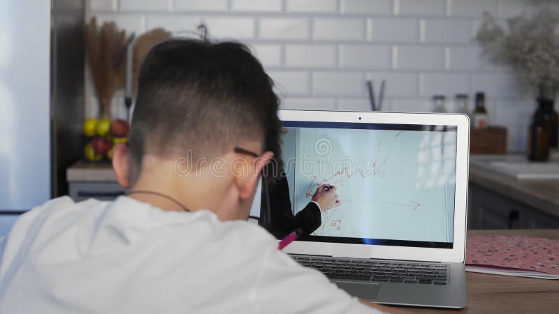A View from the Shoulder of a Boy Doing Homework. Graphs on the Laptop ...