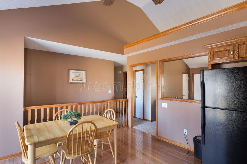 View of a Simple Wooden Table with Chairs and a Black Fridge Inside the ...