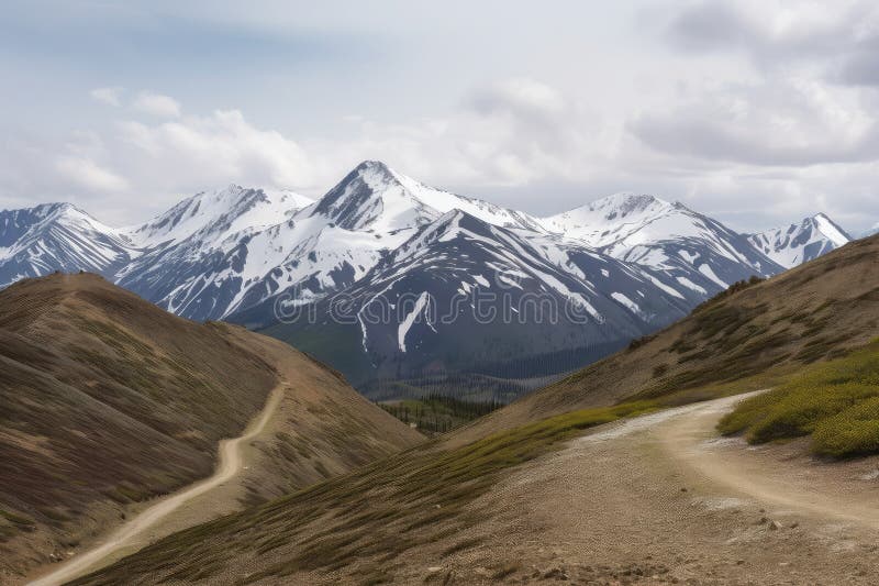 View of Snowy Peaks with Rugged Terrain from Winding Mountain Road ...