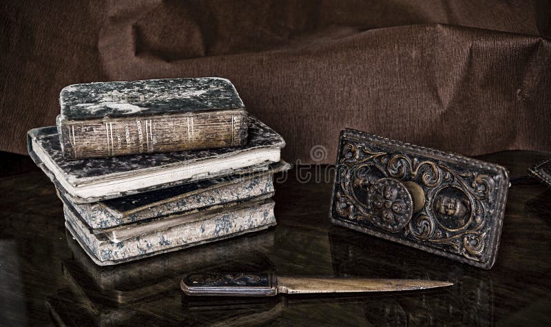 View at a Stack of Ancient Stained Books by a Metallic Artifact and an ...