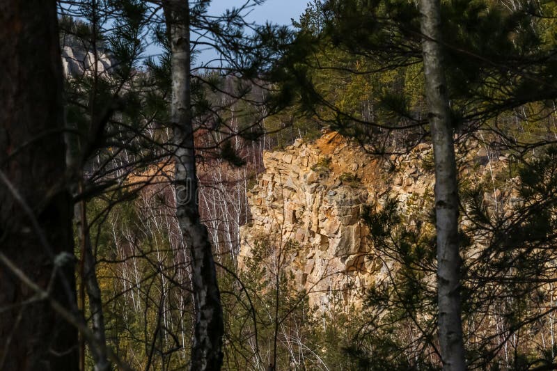 View of the Stone Cliffs of a Granite Quarry. Around is a Pine Forest ...