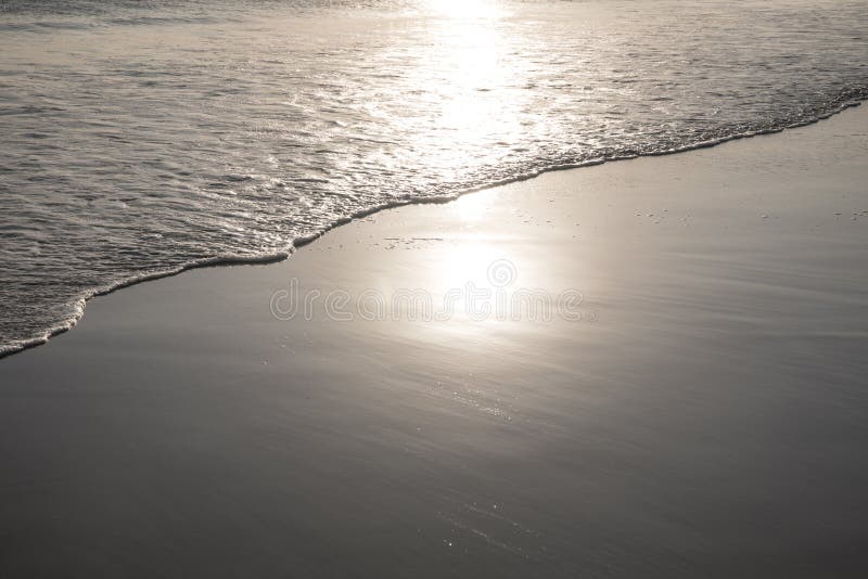 View of Sun Reflecting on Wet Beach Sand with Water Pulling Back Stock ...