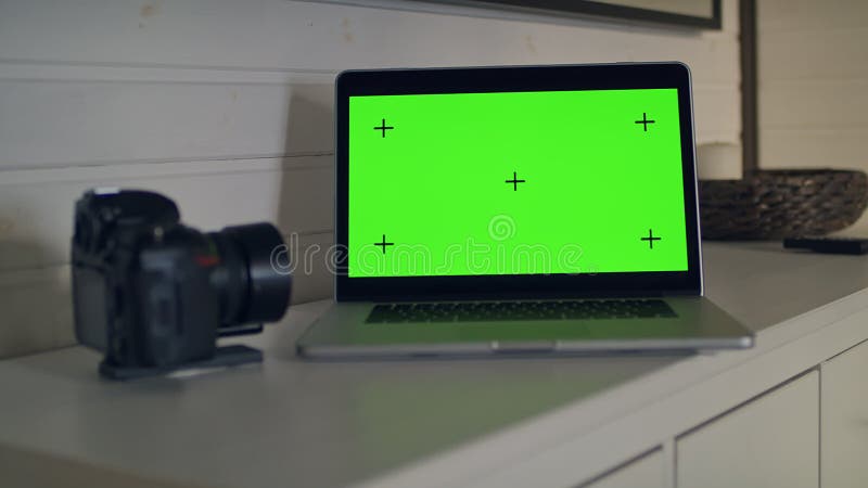 View of a Table with a Laptop Computer with a Green Screen. Stock ...