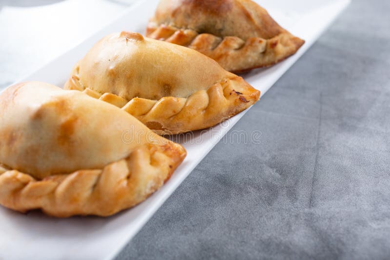 Three empanadas on a plate stock photo. Image of south - 281965440