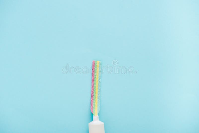 View of Toothpaste Tube with Chewing Colorful Candy Isolated on Blue ...