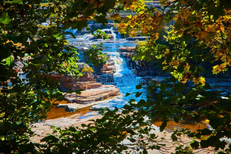 View through Trees of Cascading Waterfalls Over Cliffs Stock Image ...