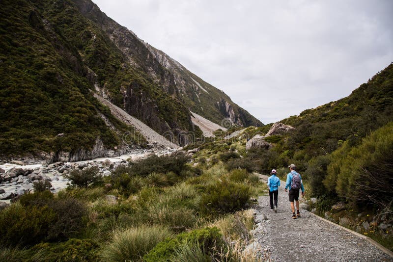 View of Two People Hiking in the Tree-covered Cliffs with a River ...
