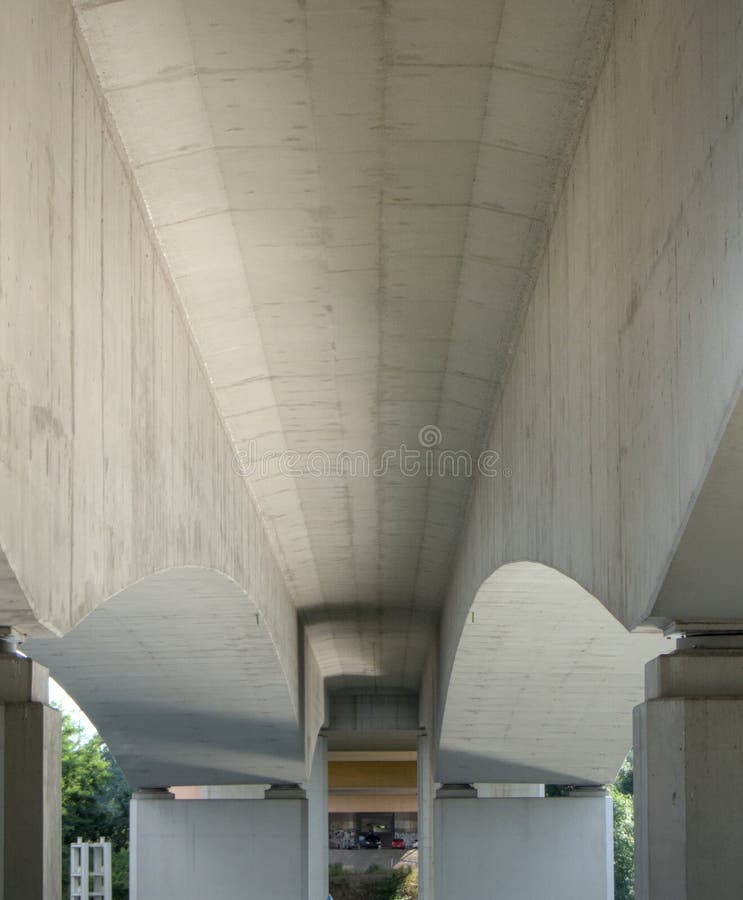 View from Under a Concrete Bridge with Large Pillars and a Road Visible ...