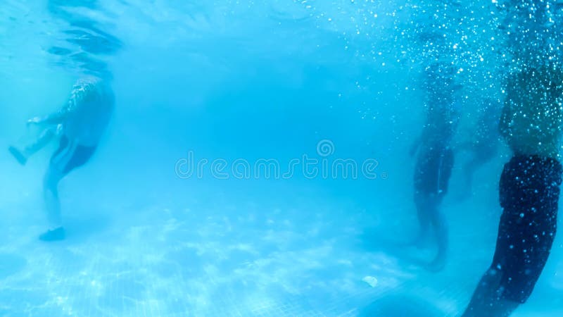 View from Under Water at Swimming Pool on People Swimming and Relaxing ...