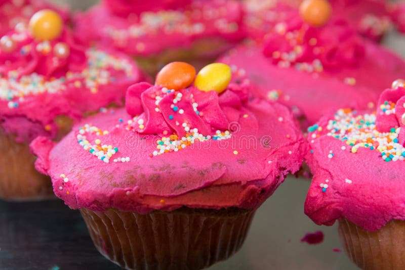 Cupcakes Covered in Bright Red Icing Sugar with Some Candy on Top ...
