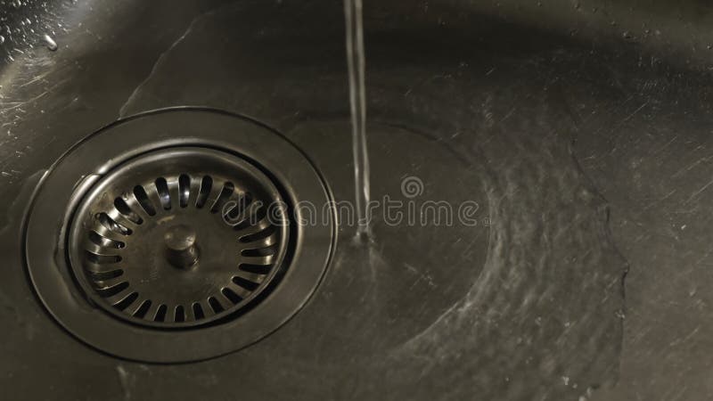 View of the Water Running from the Tap To Kitchen Sink. Concept. Close ...