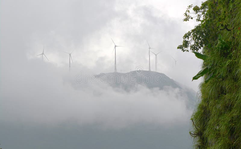 View of Wind Turbines on the Top of the Hill in the Mist. Stock Photo ...