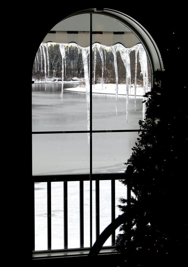 View through Window at Frozen River with Christmas Tree Next To it ...