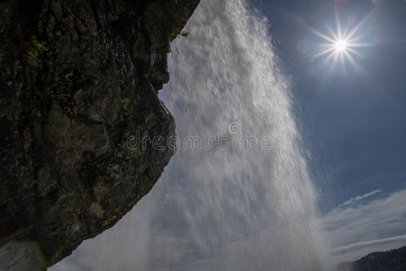 Viewing from the Inside of a Waterfall with a Bright Sun and Sun Flare ...