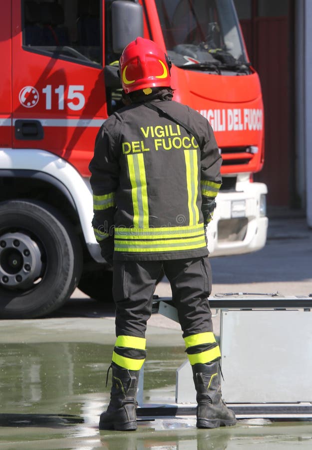 Vigile Del Fuoco Italiano Con L'uniforme Protettiva E Casco Sulla H ...