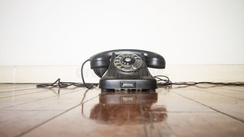 A Vintage Black Phone Ringing Off the Hook on a Wooden Floor Stock ...