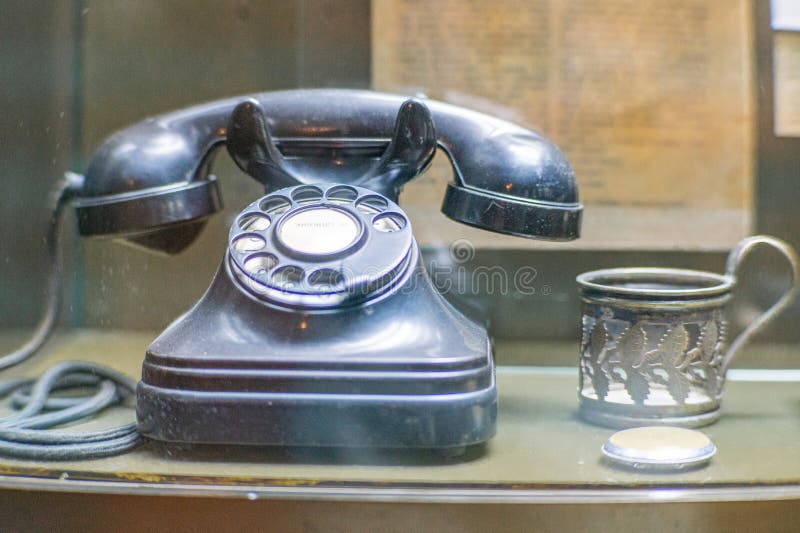 A Vintage Black Rotary-dial Telephone Sits on a Surface, with Two ...