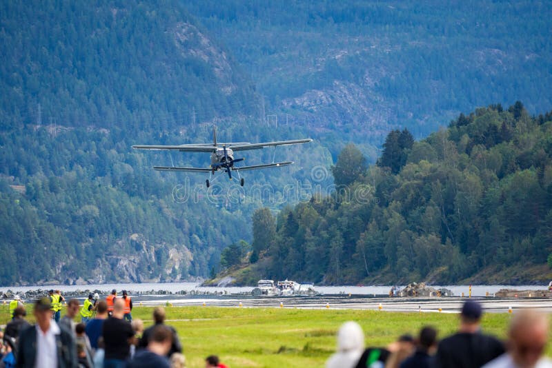 Vintage Double-decker Airplane Landing with Spectators at Runway Stock ...